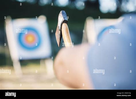 Man Throwing Axe At Sports Range Archery Training Or Practice With