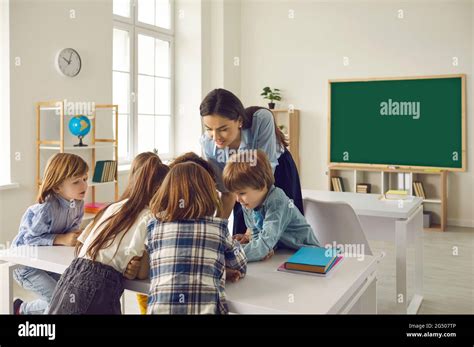 Une Enseignante Aide Les Enfants Dans Leur Travail En Classe à Lécole