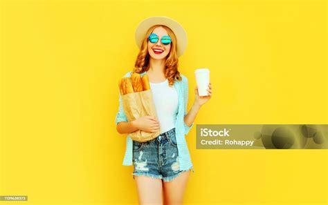 행복 한 웃는 젊은 여자 긴 흰 빵 바게트 커피 컵을 들고 종이 가방 밀 짚 모자를 입고 화려한 노란색 배경에 반바지 가방에 대한 스톡 사진 및 기타 이미지 Istock