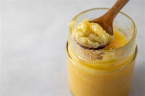 Ghee em um frasco de vidro feito óleo de girassol em um fundo claro