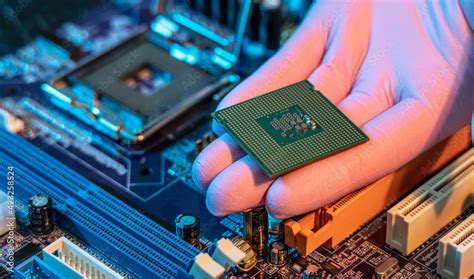 Engineer S Gloved Hand Is Holding The CPU Chip On The Background Of The Motherboard High Tech