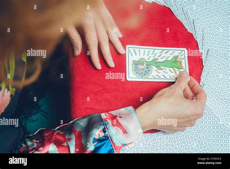 Top View Unrecognizable Caucasian Woman Tarot Reader Holding Card With Her Hands On Table