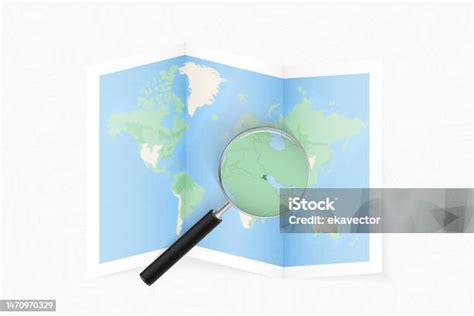 Enlarge Kuwait With A Magnifying Glass On A Folded Map Of The World