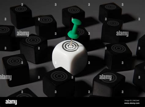 A White Cube With A Target And A Green Pushpin Stands Out Among A Black Cubes Goal Setting
