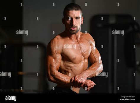 Un Sano Uomo In Piedi Forti In Palestra E Flettendo I Muscoli