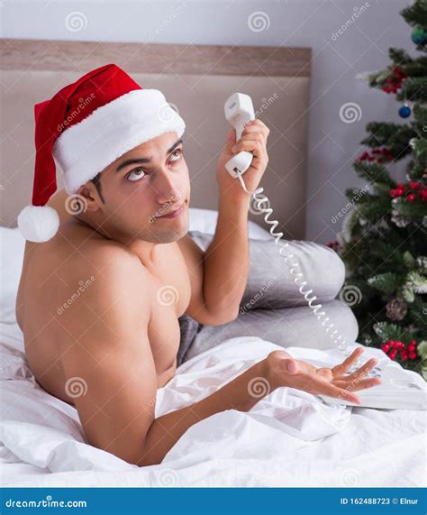 Hombre Sexy En La Cama Con Sombrero Santa En Concepto De Navidad Imagen De Archivo Imagen De
