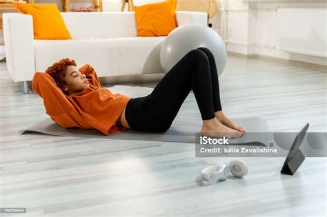 피트니스 운동 훈련 젊은 건강 적합 아프리카 소녀는 집에서 바닥에 요가 매트에서 자전거 크런치 복근 운동을 하고 있다 운동복을