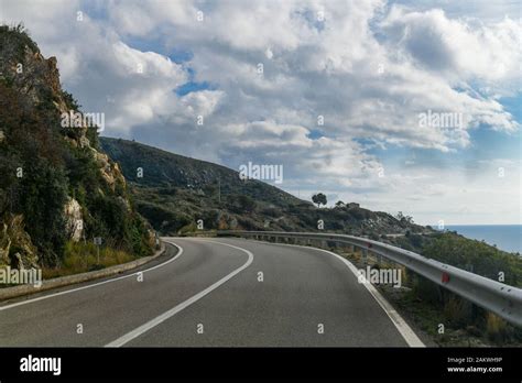 A Sharp Bend On An Empty Tarmac Road With Street Signs Edge Of The