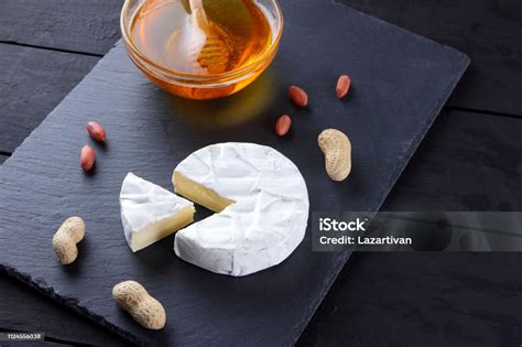 카망베르와 검은색 꿀 슬레이트 보드 금형과 땅콩에 부드러운 치즈 치즈와 견과류 돌 보드에 공간 복사 0명에 대한 스톡 사진 및