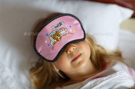 Little Caucasian Girl With Blonde Hair Wearing Blindfold When Sleeping