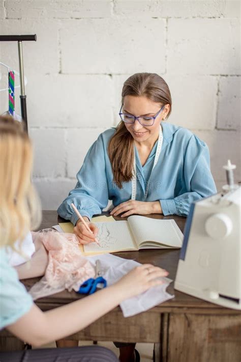 Female Seamstress Discussing Features Of The Order With Client In Cozy