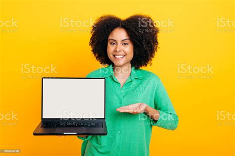 녹색 셔츠를 입은 즐거운 브라질 또는 아프리카계 미국인 곱슬머리 여성 흰색 빈 모형 화면이 있는 열린 노트북을 손에 들고 손을