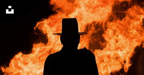 모자와 코트를 입은 남자가 큰 사람 앞에 서 있는 실루엣 사진 Unsplash의 무료 불 이미지