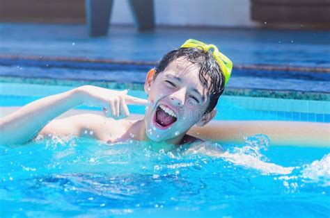 Dos Muchachos En La Piscina Que Salpica El Agua Y Que Se Divierte Foto