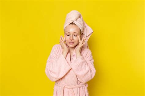 Free Photo A Front View Young Beautiful Female In Pink Bathrobe Rubbing Her Face With Cream