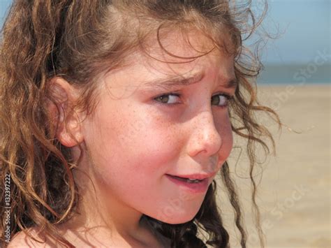 Portrait Of A Pretty Girl On The Beach Looking At Us And Frightened