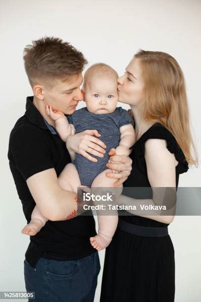 통통한 케루빅 아기 유아와 함께 어두운 옷을 입은 젊은 매력적인 가족의 초상화가 흰색 배경에 서 있습니다 20 24세에 대한 스톡 사진 및 기타 이미지 Istock