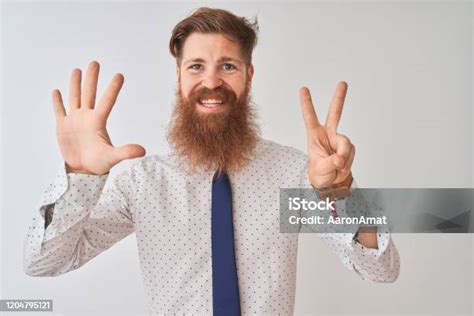 젊은 빨간 머리 아일랜드어 사업가 는 자신감과 행복 미소하면서 손가락 번호 7을 표시하고 가리키는 고립 된 흰색 배경 위에 서있다 7에 대한 스톡 사진 및 기타 이미지