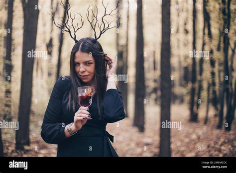 Mysterious Woman Wearing Gothic Deer Antlers Headband With Mulled Wine