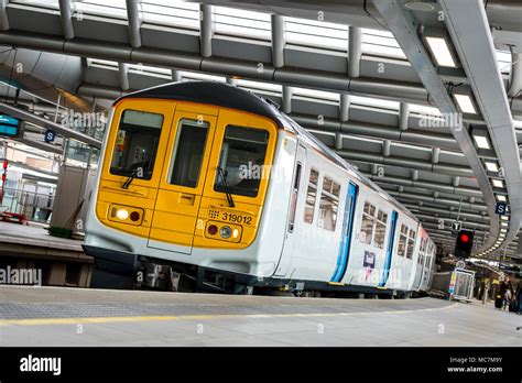 Class 319 Passenger Train In Thameslink Livery Arriving At A Railway