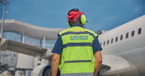 대형 여객기 앞에 서 있는 소음 제거 헤드셋을 착용한 감독자의 뒷모습 사진 Unsplash의 따뜻한 옷 이미지