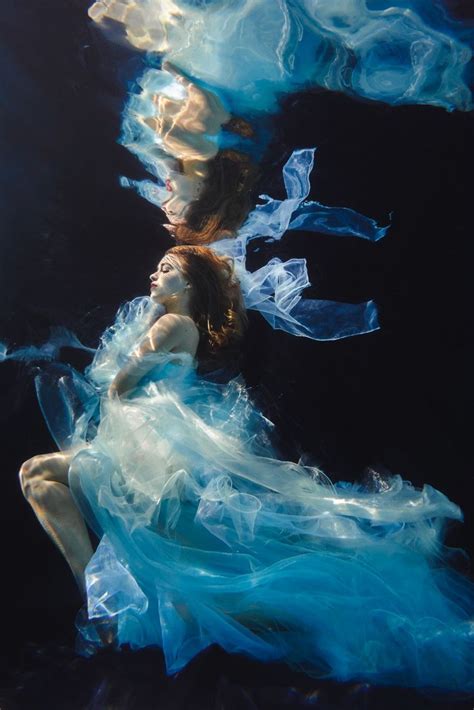 Two Women In Blue Dresses Floating Under Water