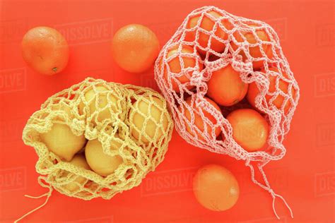 Overhead View Of Two Reusable String Shopping Bags Filled With Oranges