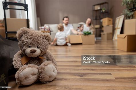 결혼 한 부부는 이사하는 과정에 있으며 새 아파트에 앉아 천천히 자녀와 함께 소지품 상자를 풀고 이야기하고 웃고 장소 변화를 즐기고 토론합니다 부동산에 대한 스톡 사진 및