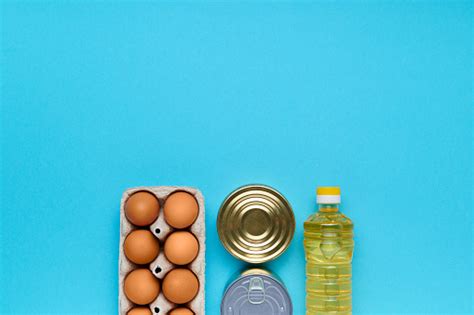 상단 보기 플랫레이 카피 스페이스 파란색 배경에 있는 제품 집합입니다 가게에서 식품포장 해바라기 기름 계란 통조림 식품 배달 및