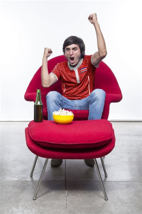 Hincha De Fútbol Con Camiseta De Su Equipo En Sillón Rojo Foto De