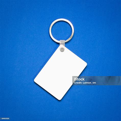 파란색 배경에 흰색 키 링입니다 디자인에 대 한 키 체인입니다 매달려 액세서리 또는 기념품입니다 열쇠고리에 대한 스톡 사진 및