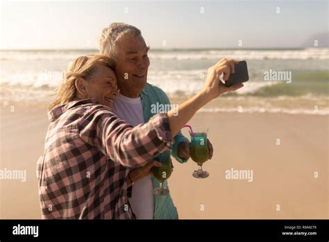Senior Couple Taking Selfie With Mobile Phone While Having Cocktail