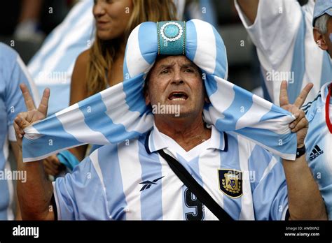 A Male Argentinian Football Fan Wearing A Funny Hat Sings In The Crowd