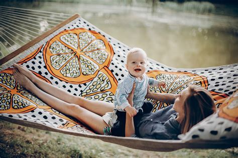 젊은 Hipster 어머니 여름 화창한 공원에 해먹에 그녀의 귀여운 작은 아들 놀고 아이 숲에서 휴식 하 고 웃 고 재미와 함께 세련 된 행복 한 엄마 텍스트를 위한