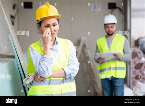 Crying Female Builder At Construction Site With Displeased Foreman