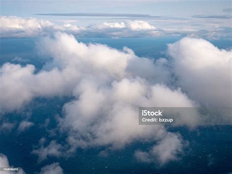 화창한 날에 아이슬란드 섬의 남서쪽에 있는 화산산의 눈 덮인 꼭대기 비행기 창문에서 구름을 통해 공중 풍경 보기 겨울에 대한