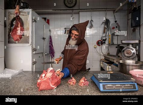 Butcher Cutting A Piece Of Meat In His Small Shop In The Sefrou Medina