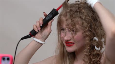A Woman Styles Hair Using A Curling Wand Manual Wrapping Of Long Hair