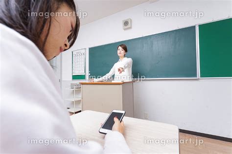 授業中にスマホを使う学生と注意する教師の写真素材 113632734 イメージマート