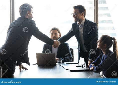 Smiling Businesspeople Handshake Closing Deal At Briefing Stock Photo
