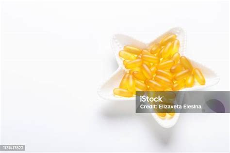 오메가 3 캡슐 별 모양 접시에 흰색 배경 생선 기름 노란 소프트 젤 비타민 D E 보충 간 내부 기관에 대한 스톡 사진 및 기타 이미지 Istock