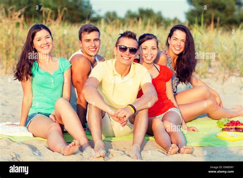 Smiling Friends Sitting On Beach Hi Res Stock Photography And Images Alamy