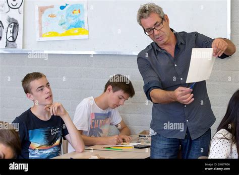 Teacher With Student In A Classroom In A Secondary School During Art