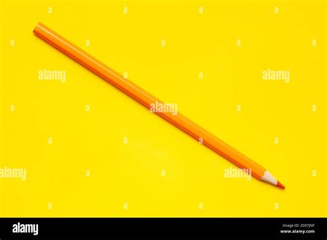 Diagonal Orange Sharp Wooden Pencil On A Bright Yellow Background