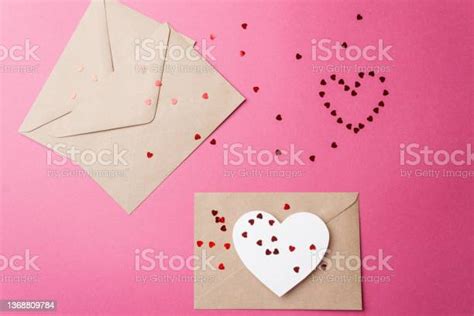 발렌타인 데이에 대한 낭만적 인 사랑 편지의 개념 하트로 뒤덮인 분홍색 배경에 흰색과 빨간색 하트가 있는 크래프트 페이퍼로 만든