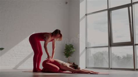 Entrenadora De Yoga Para Mujeres Ayuda Al Estudiante A Estirar La