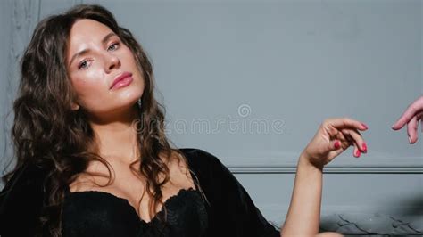 Two Girls Stand In Light Coats In The Studio And Lean Their Fingers