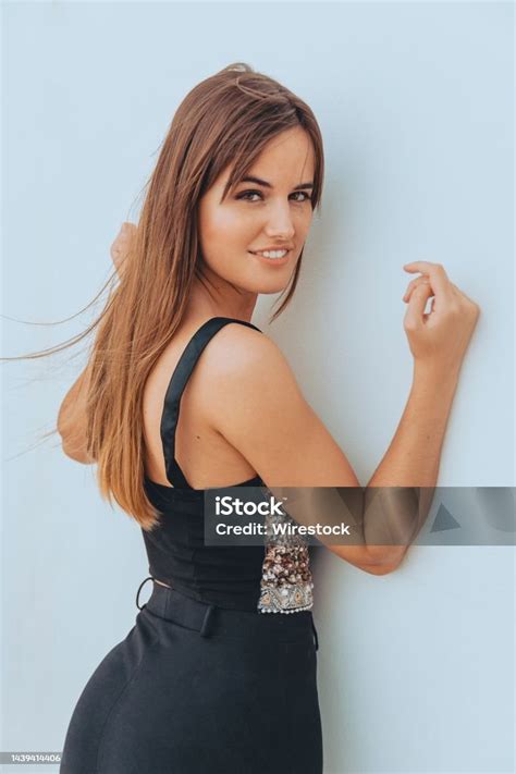 Attractive Brunette Girl Posing Near The Wall And Looking Back Over Her