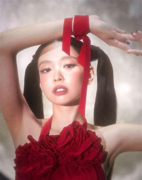 A Woman In A Red Dress With Her Hands On Her Head