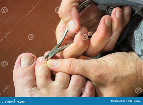 Manicure Master Trimming Cuticles On Woman Toes With Pedicure Scissors